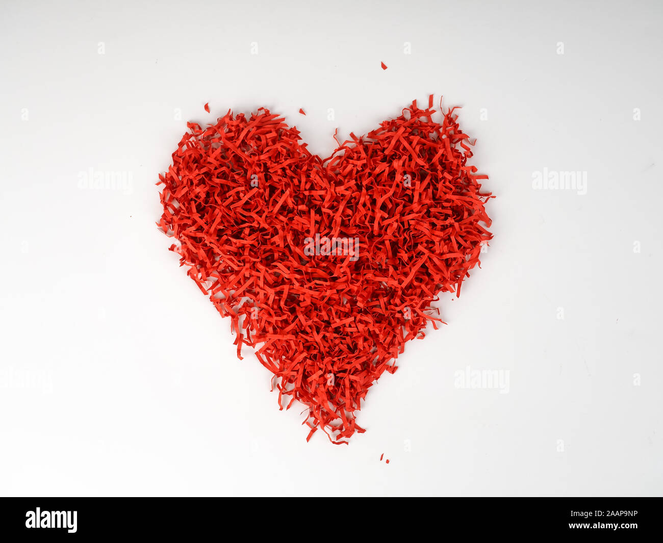 Red shredded paper in shape of heart on blue background. Heart made of ...