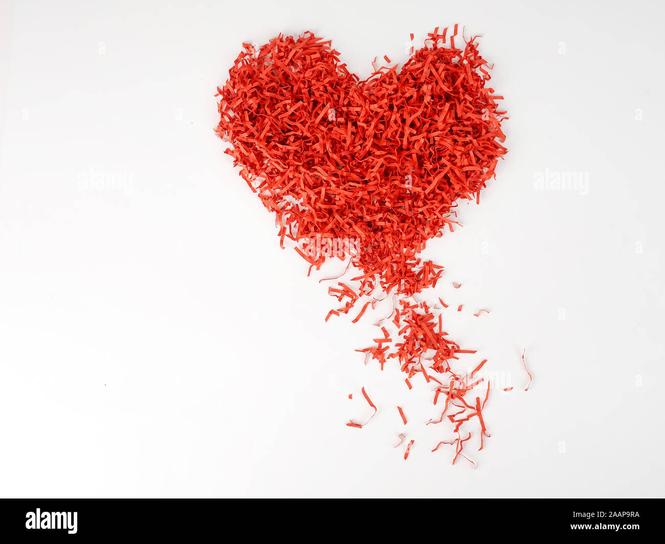 Red shredded paper in shape of heart on blue background. Heart made of ...