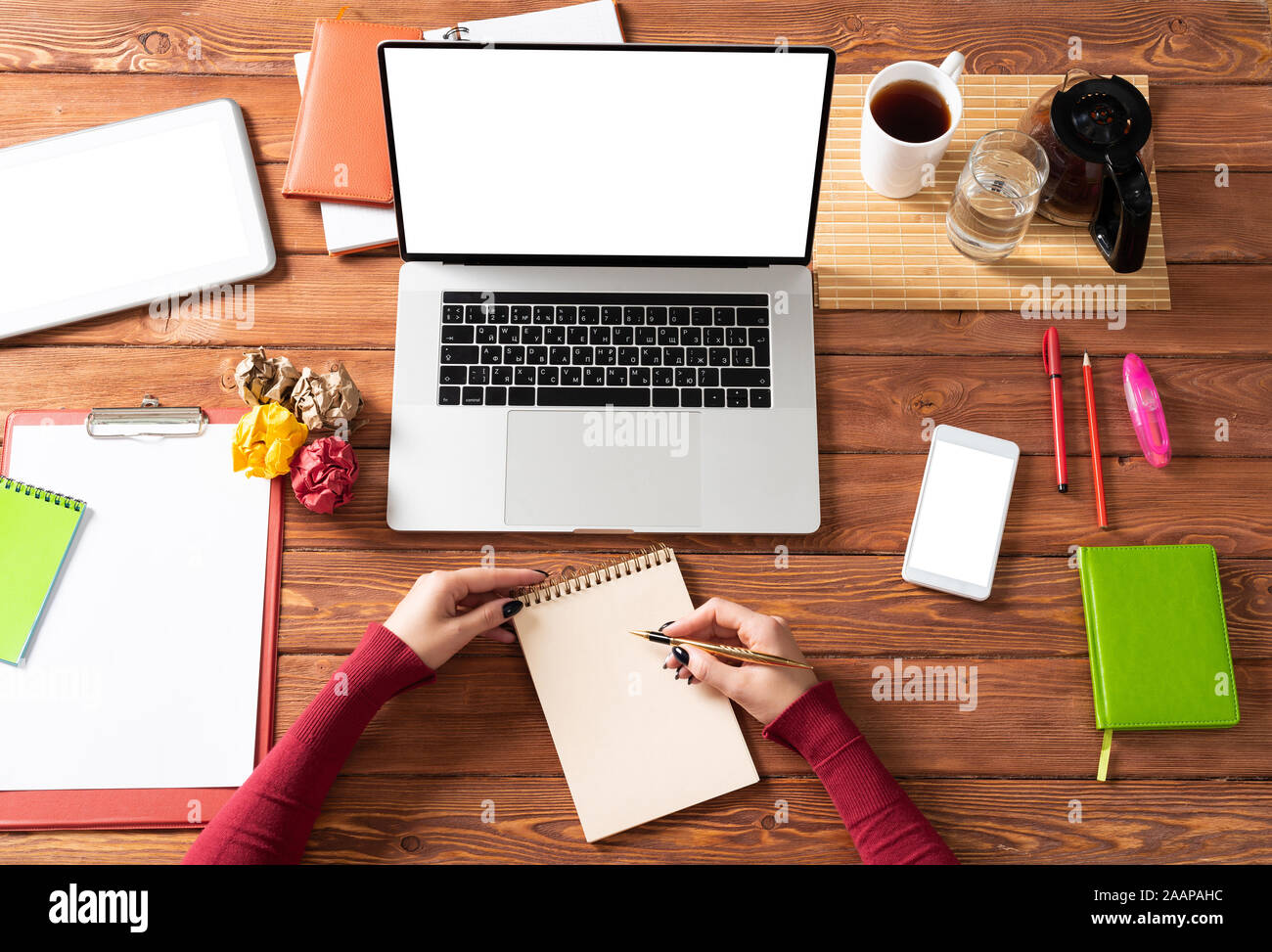 Woman writing in notebook with pen at desk Stock Photo - Alamy