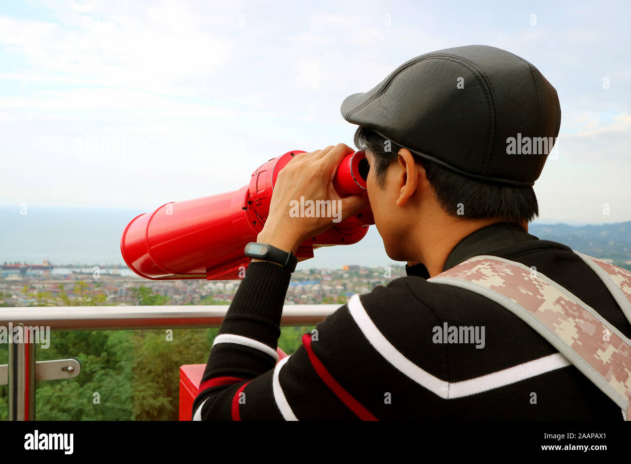 Young Man Observing Aerial City View with Binoculars from the ...