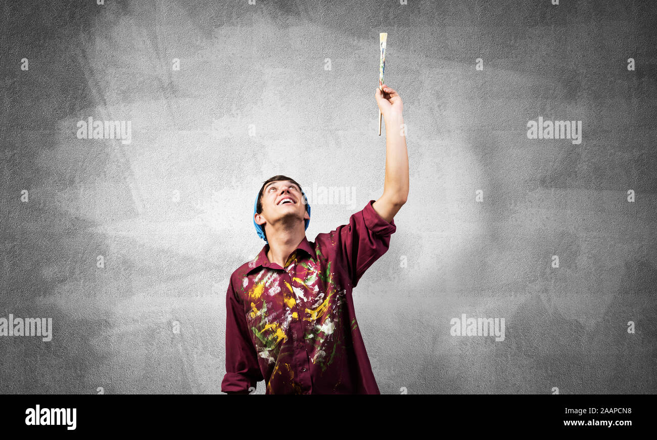 Young painter artist pointing upwards Stock Photo - Alamy