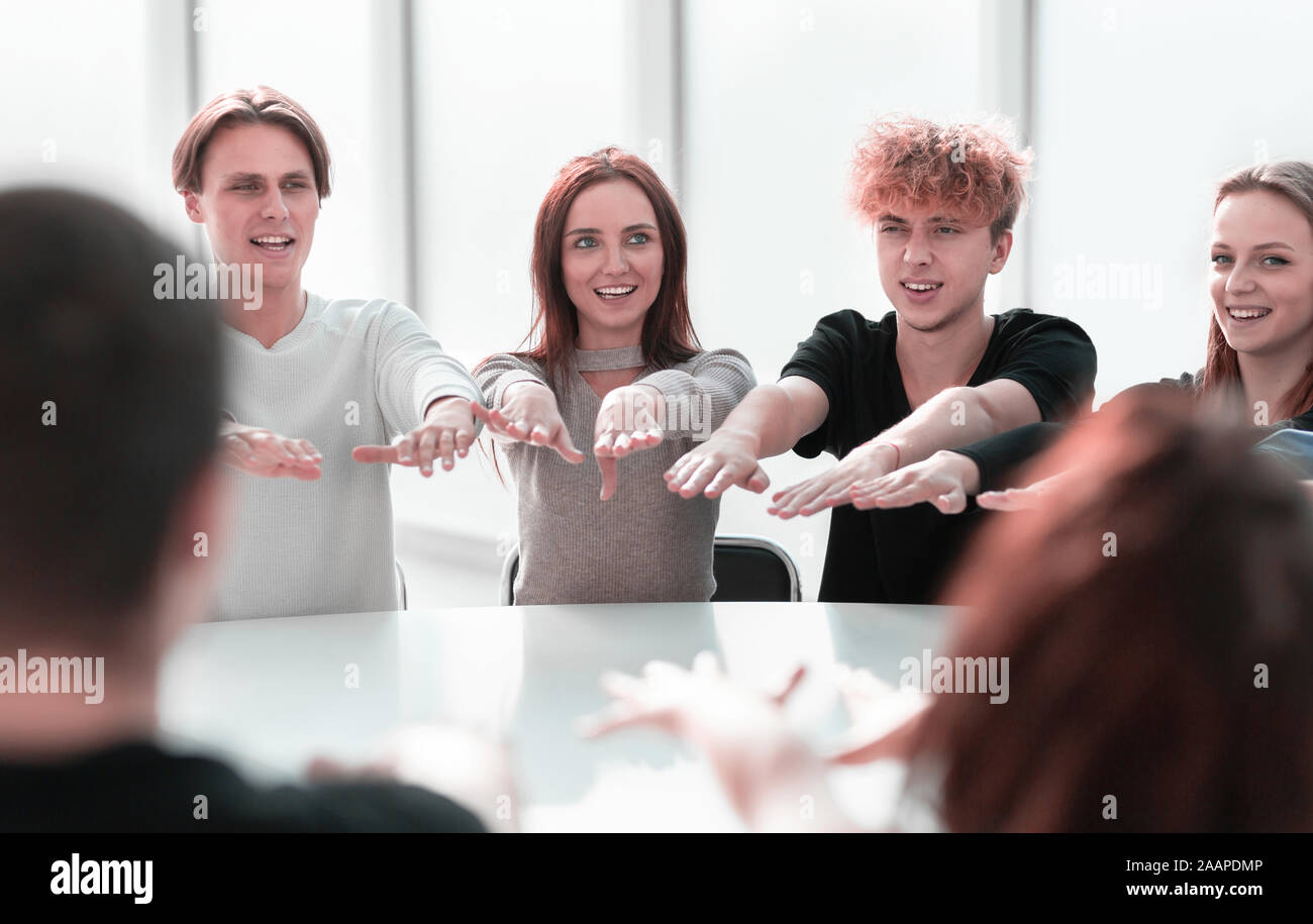 concentrated group of young people sitting at a round table Stock Photo - Alamy