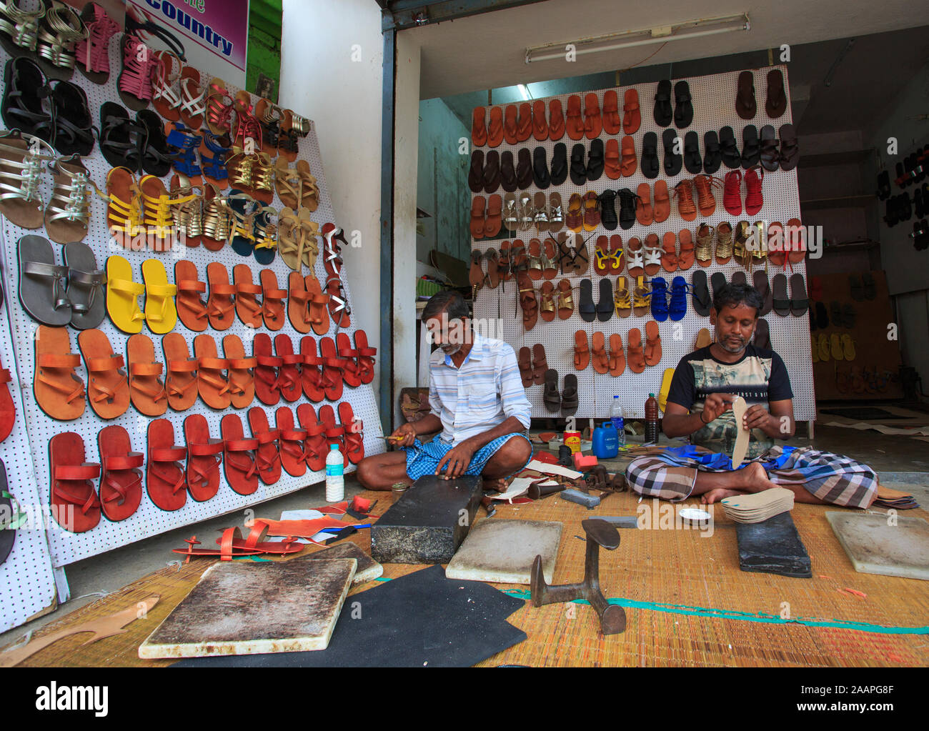 A Shoe Maker making the shoes at a roadside shop in Mahabalipuram ...