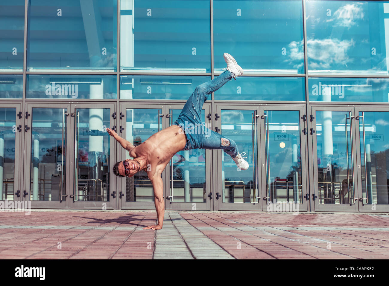 Handstand in jump, young active dancer, trained tanned torso, sport man ...
