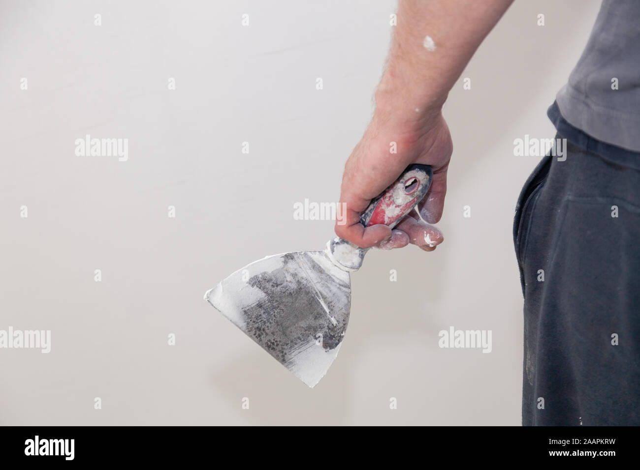 Puttyer holding spatula with putty solution. Indoors construction works ...