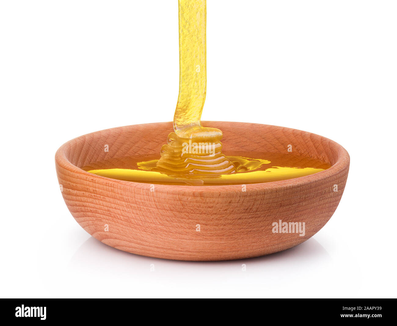 Wooden bowl full of honey and falling jet of honey on plank isolated on ...