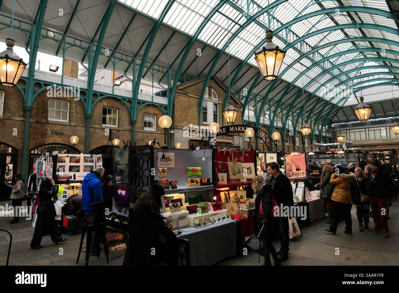 Christmas lights and busy Christmas market stalls inside Covent Garden ...