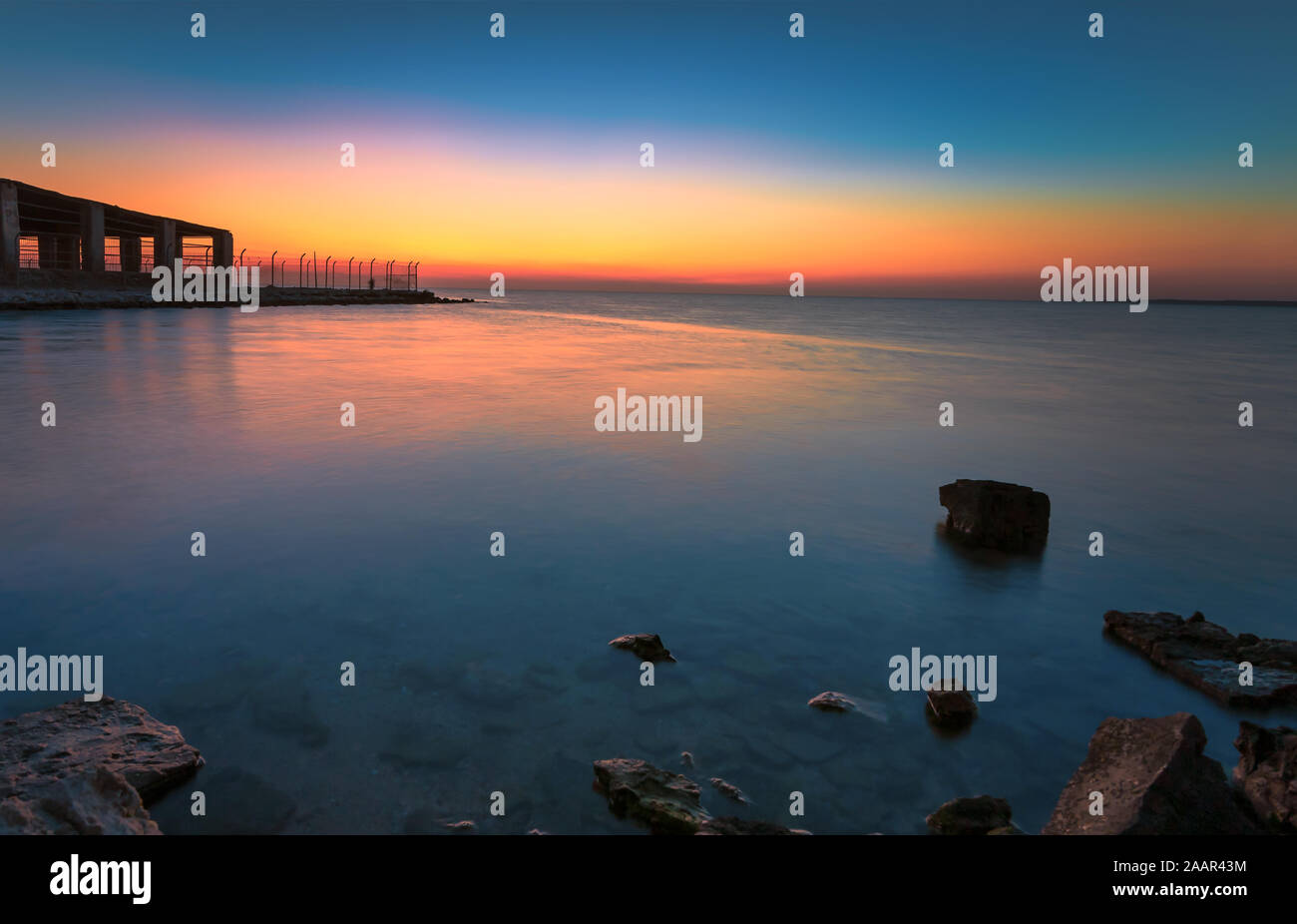 Dramatic sunrise with silky water view in Al uqair ruined fort sea side ...