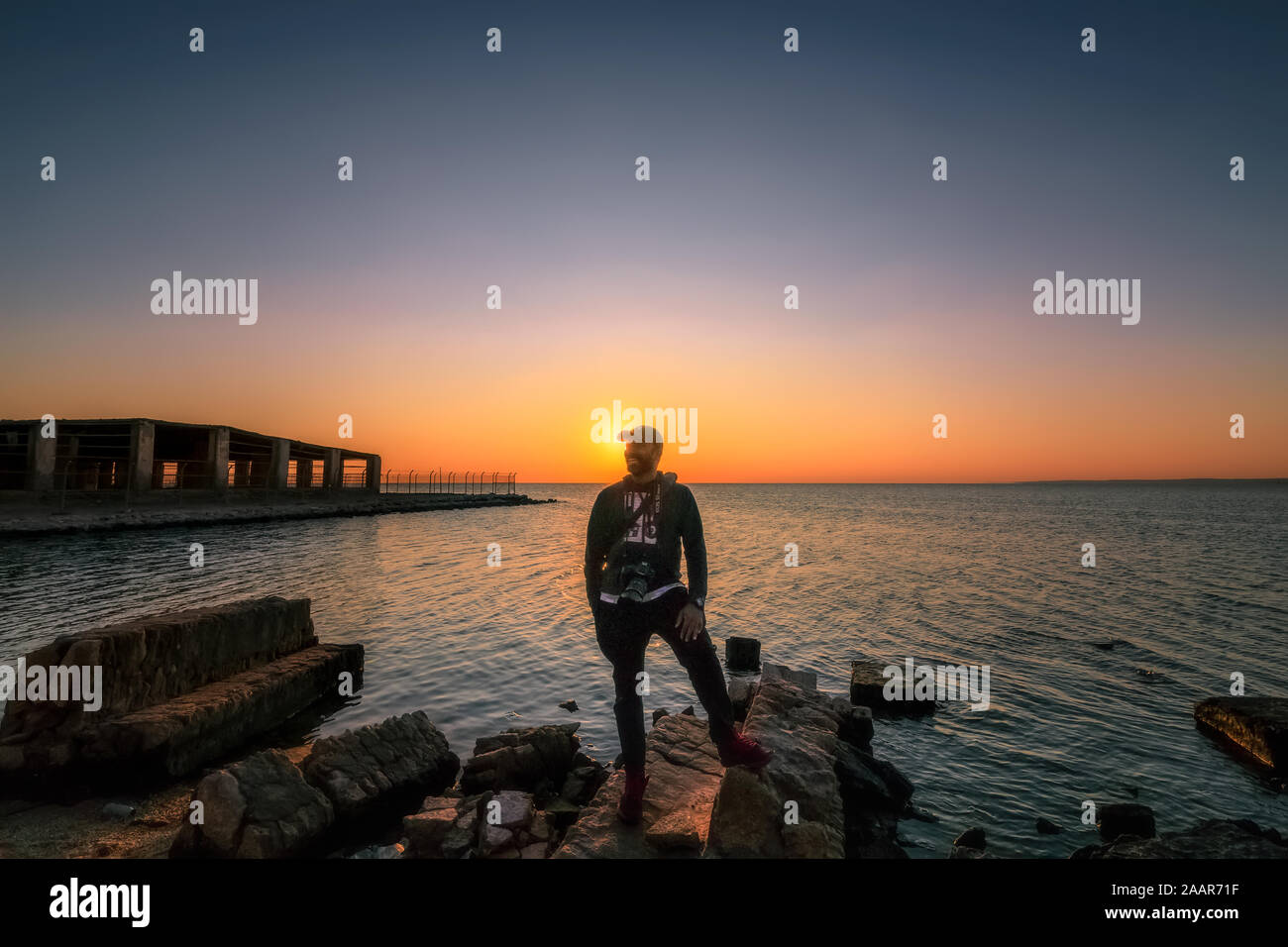 Photographer posing behind beautiful sunrise view in Al uqair ruined ...
