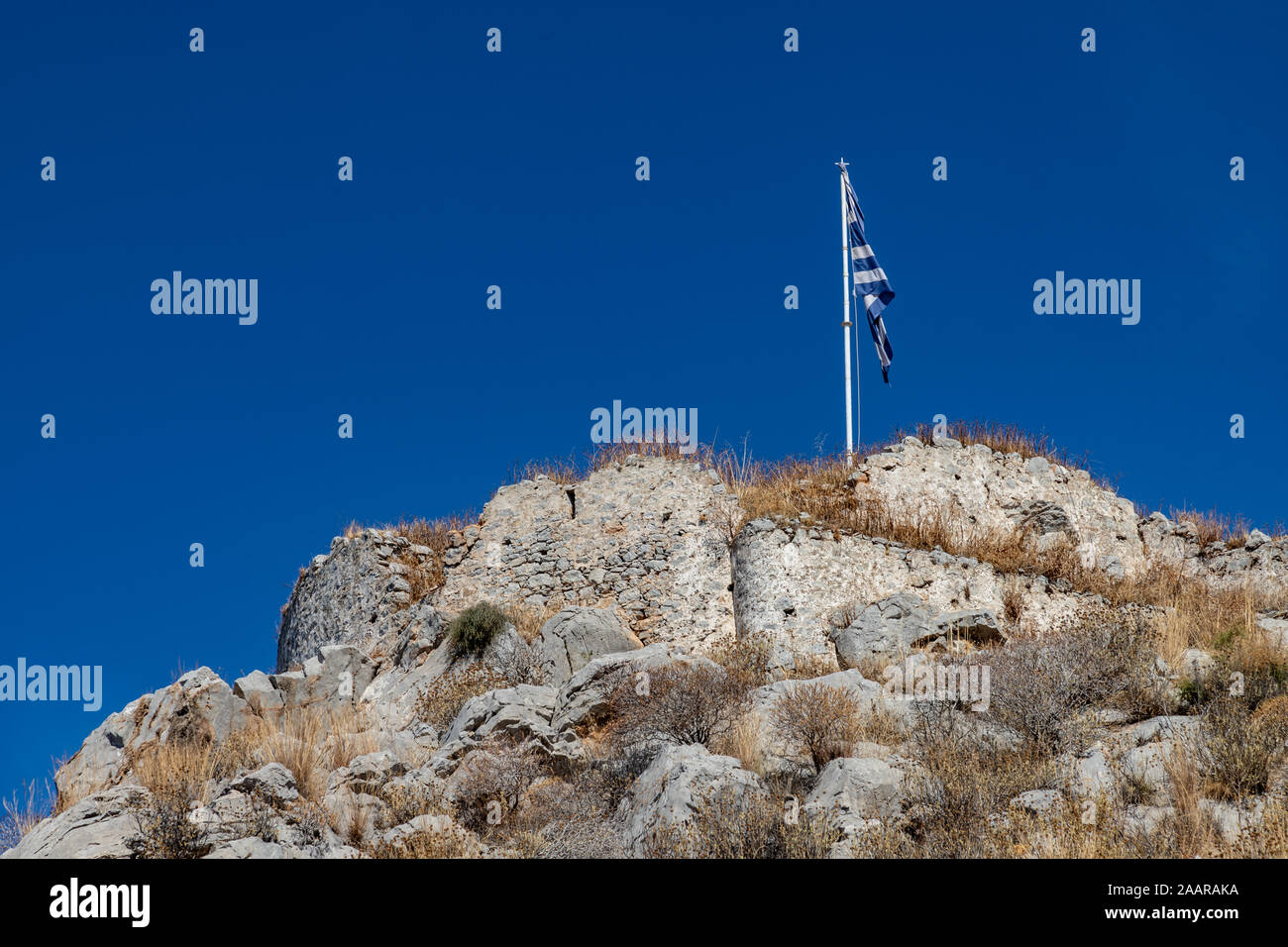 Greek flag and ruins over a mountain in Hydra Island, Greece Stock ...