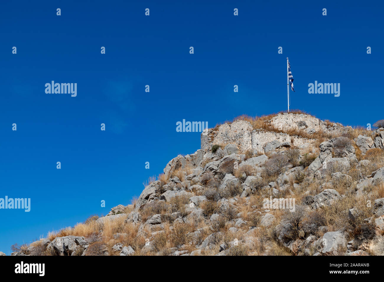 Greek flag and ruins over a mountain in Hydra Island, Greece Stock ...