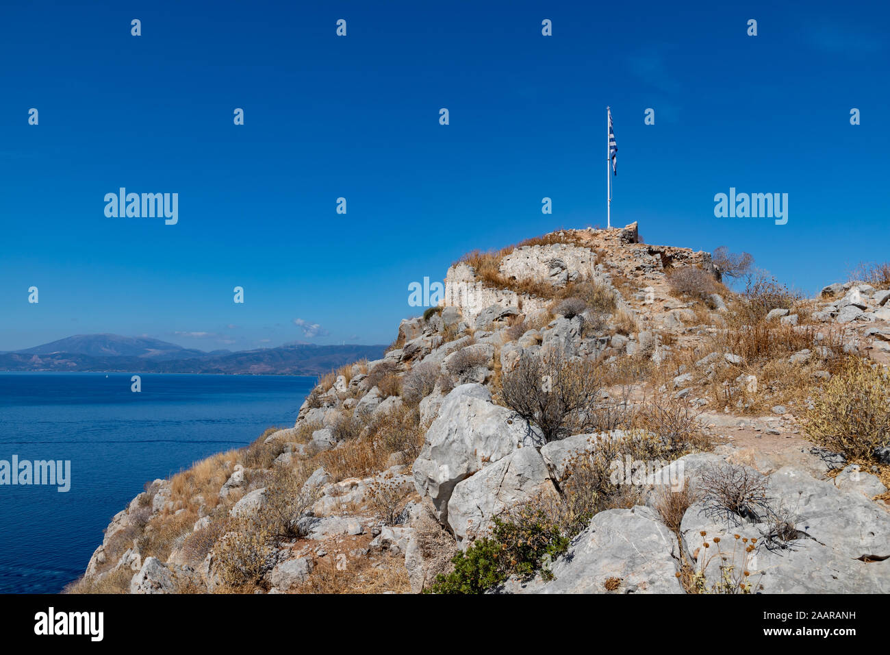 Greek flag and ruins over a mountain in Hydra Island, Greece Stock ...