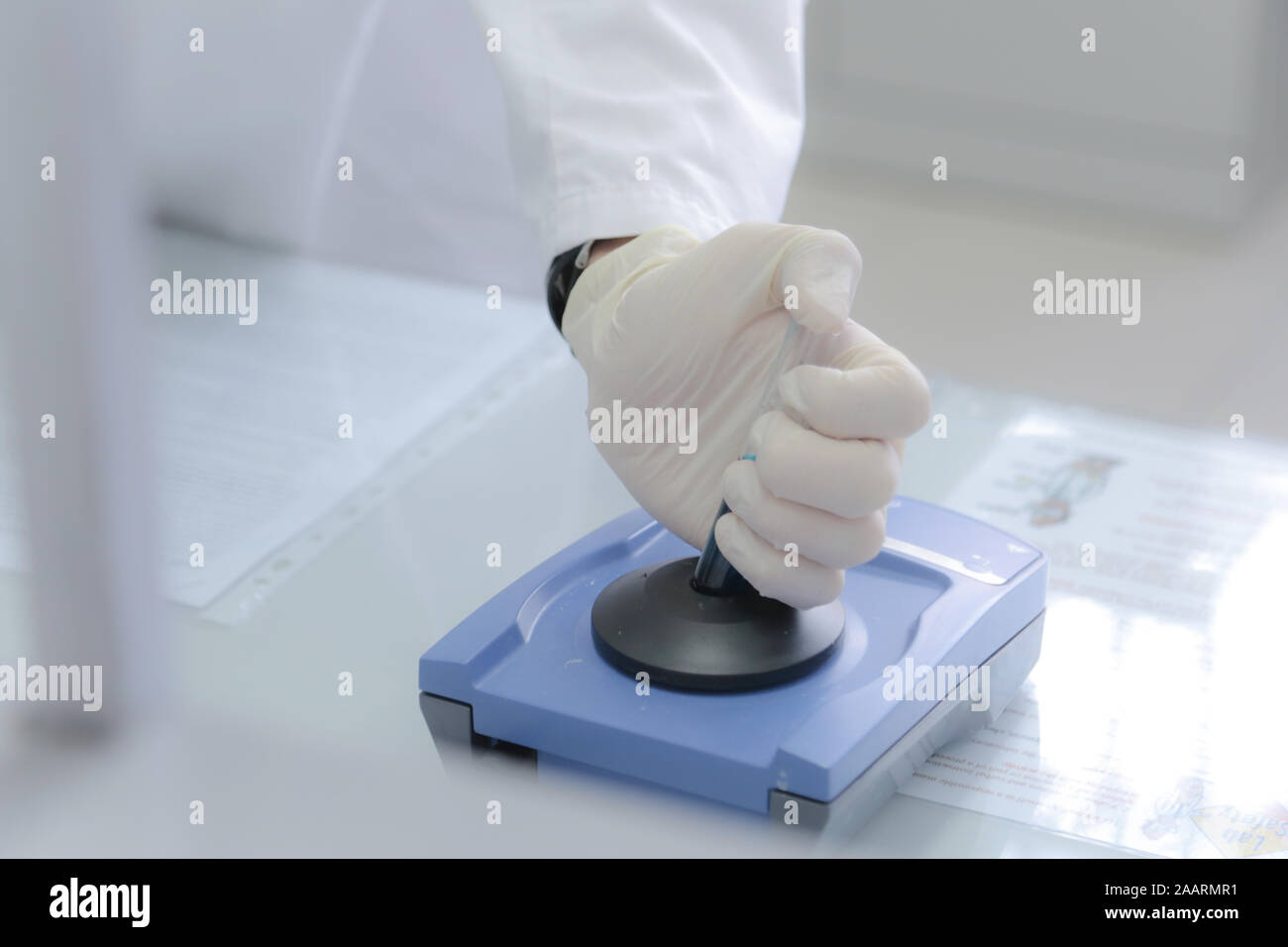 Technician loading a sample to centrifuge machine in the medical or ...