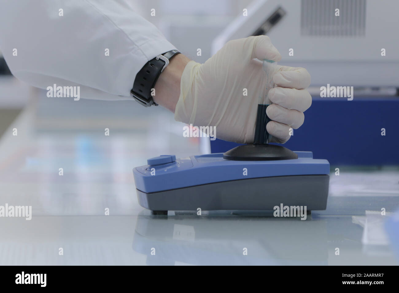 Technician loading a sample to centrifuge machine in the medical or ...