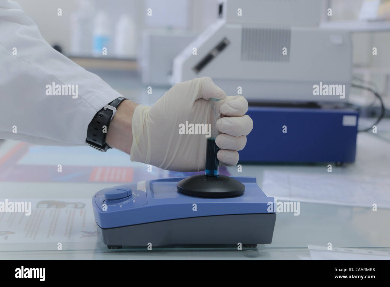 Technician loading a sample to centrifuge machine in the medical or ...