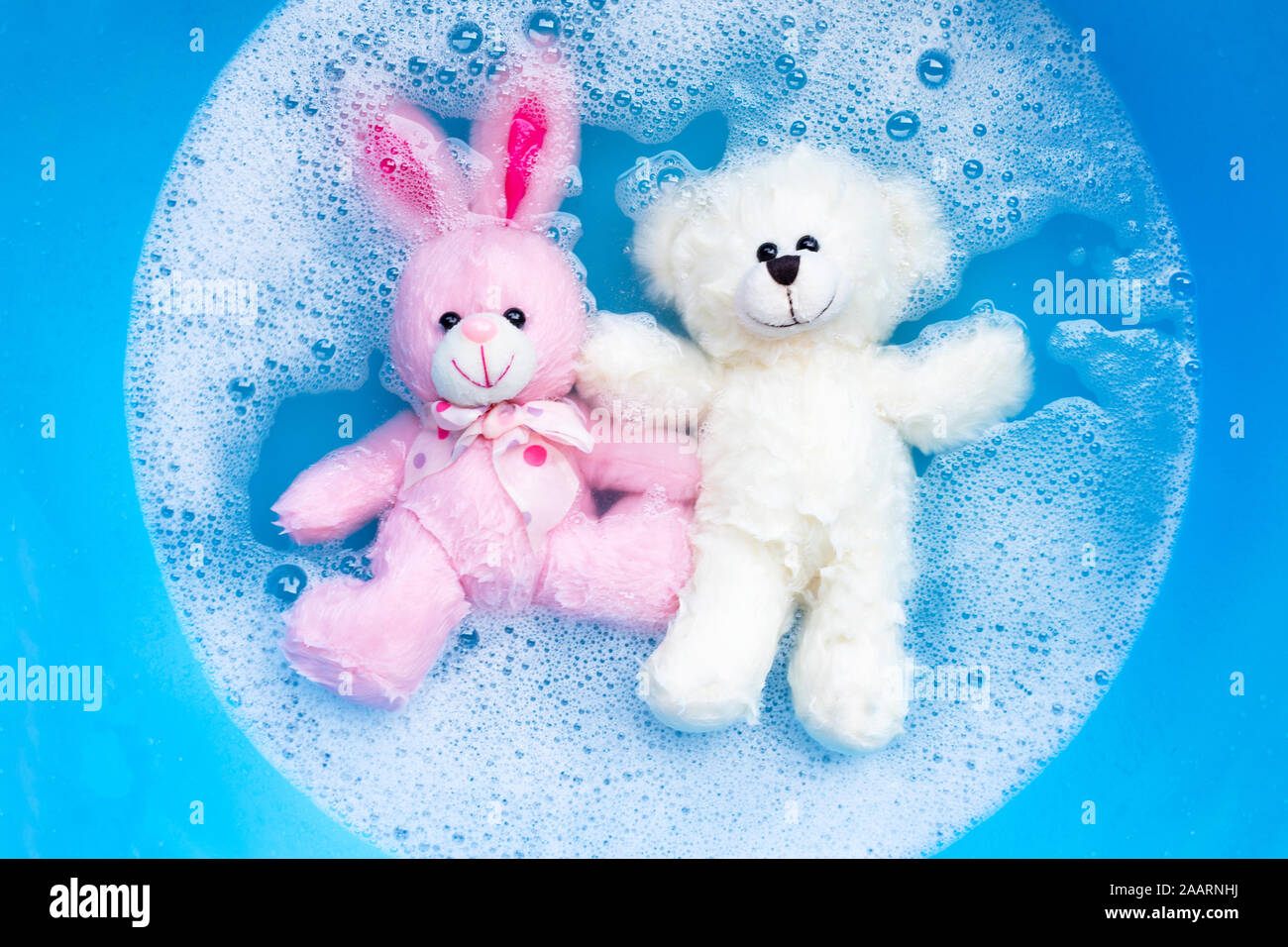 Soak rabbit doll with toy teddy bear in laundry detergent water ...