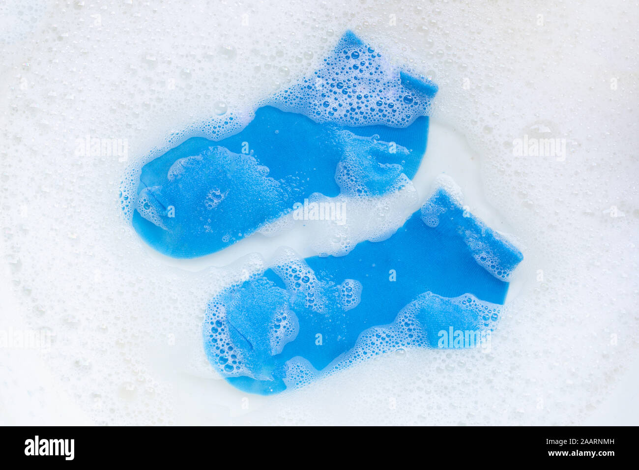 Blue socks soaking in powder detergent water dissolution. Laundry ...