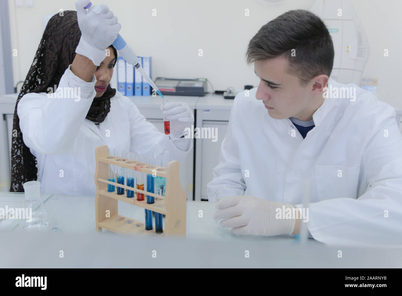 Two young male and female multiethnic, mixed race students scientists ...