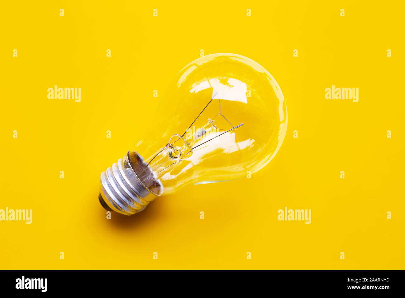 Light bulb on yellow background. Top view Stock Photo - Alamy