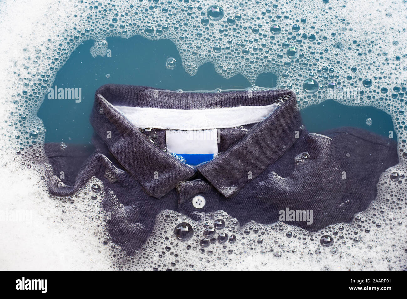 Grey polo shirt soak in powder detergent water dissolution, washing ...