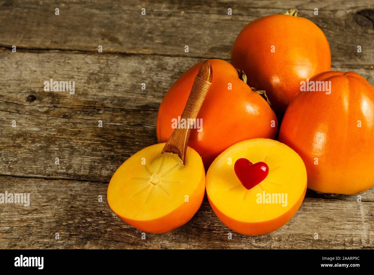 Ripe orange persimmon fruit.Kaki fruit on wooden table.Slices of ...