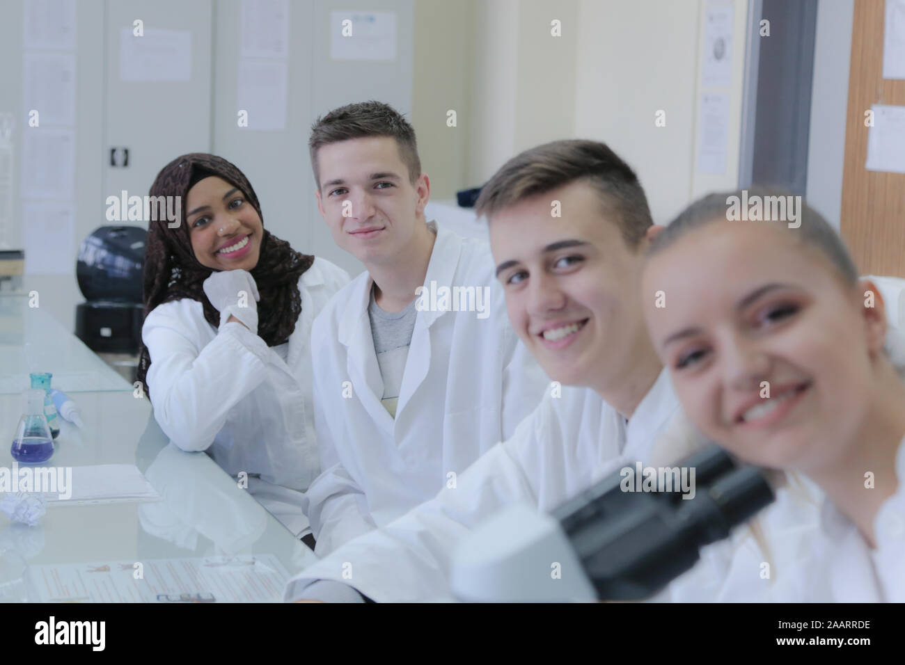 Group of young multiethnic scientists looking at camera and smilling ...