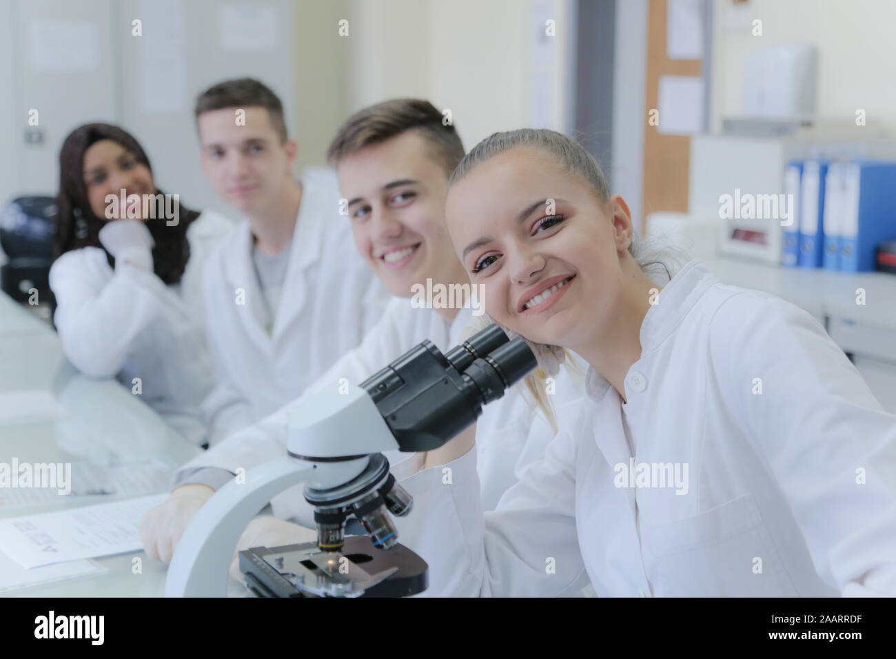 Group of young multiethnic scientists looking at camera and smilling ...