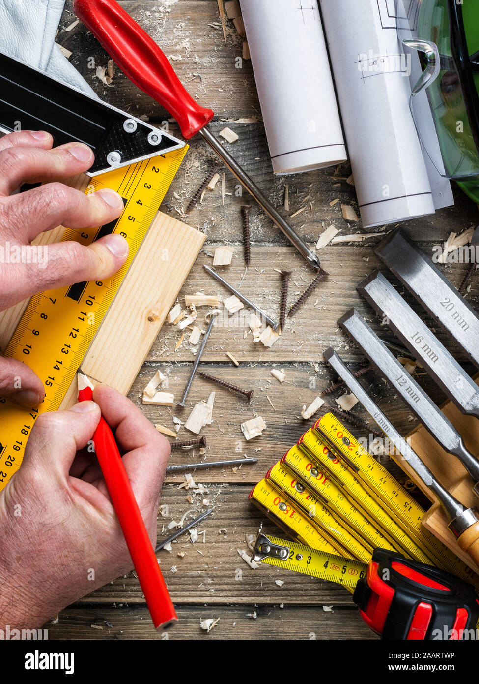 Top view. Carpenter with pencil and the carpenter's square draw the ...