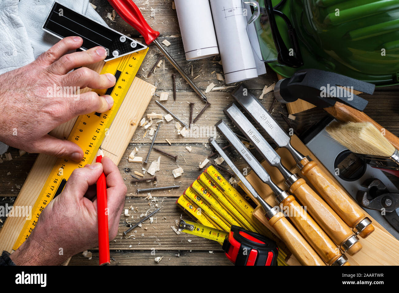 Top view. Carpenter with pencil and the carpenter's square draw the ...