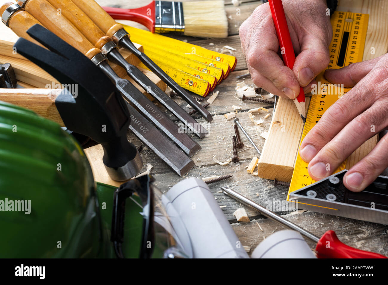 Top view. Carpenter with pencil and the carpenter's square draw the ...