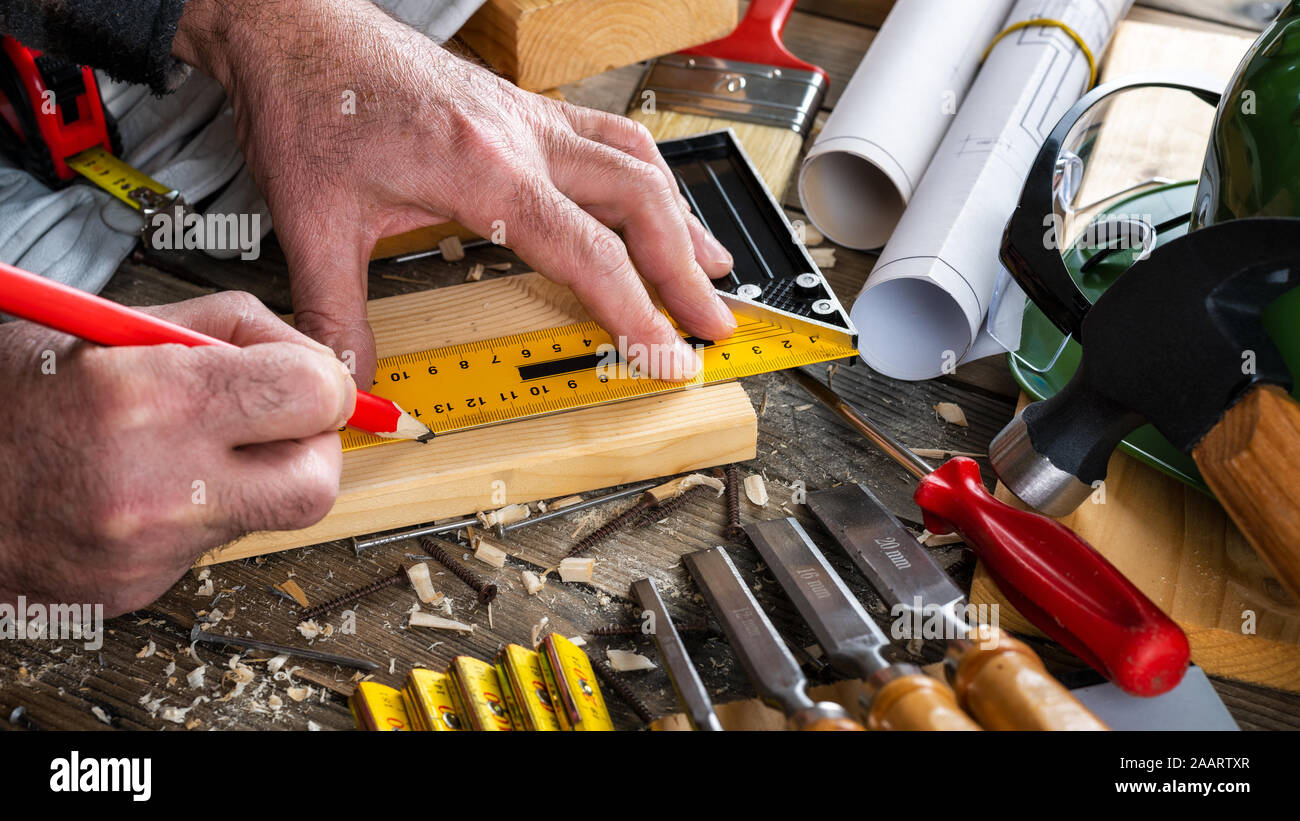 Top view. Carpenter with pencil and the carpenter's square draw the ...