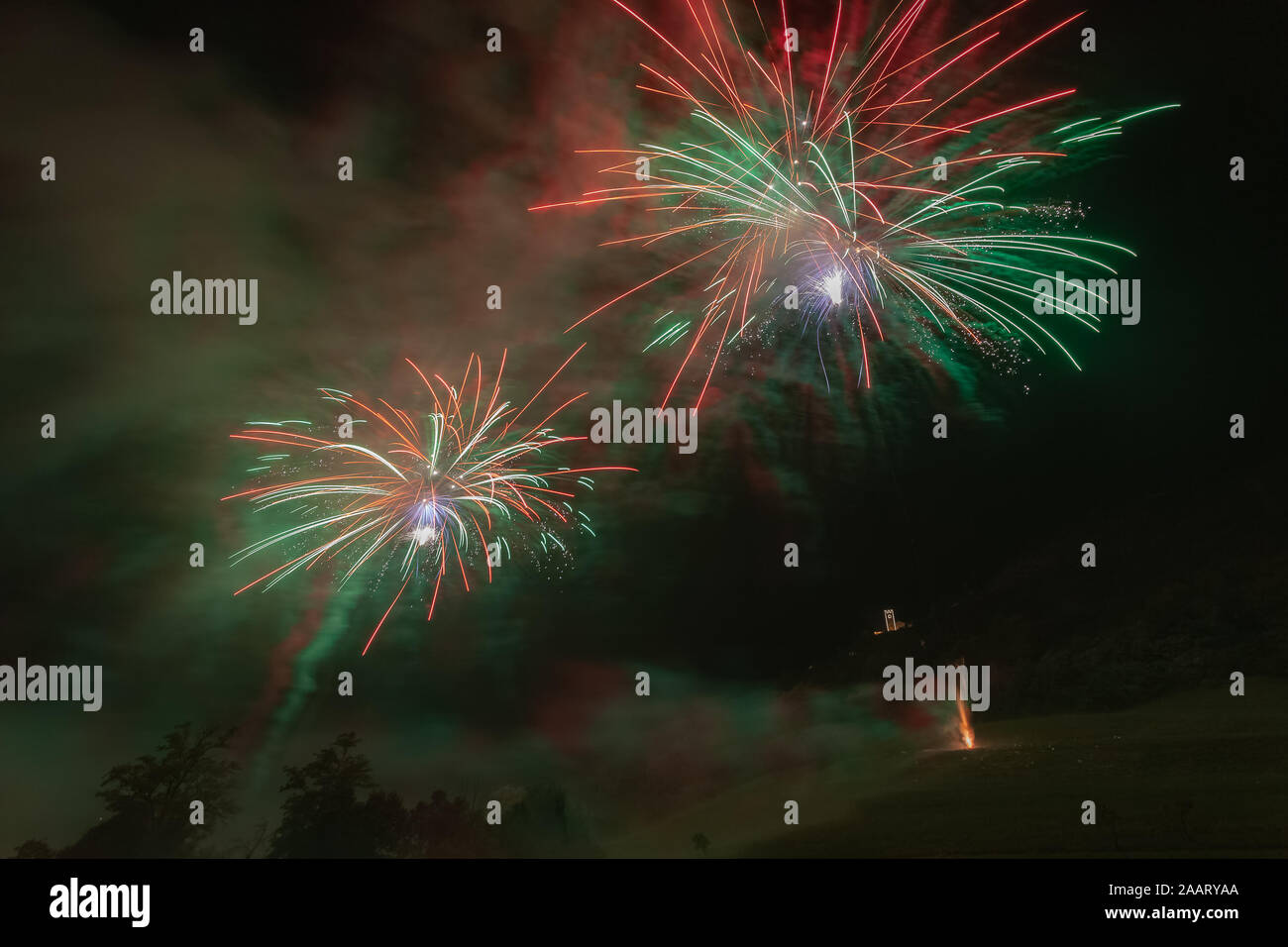 Awesome fireworks with italian flag colors lighting sky over trees ...