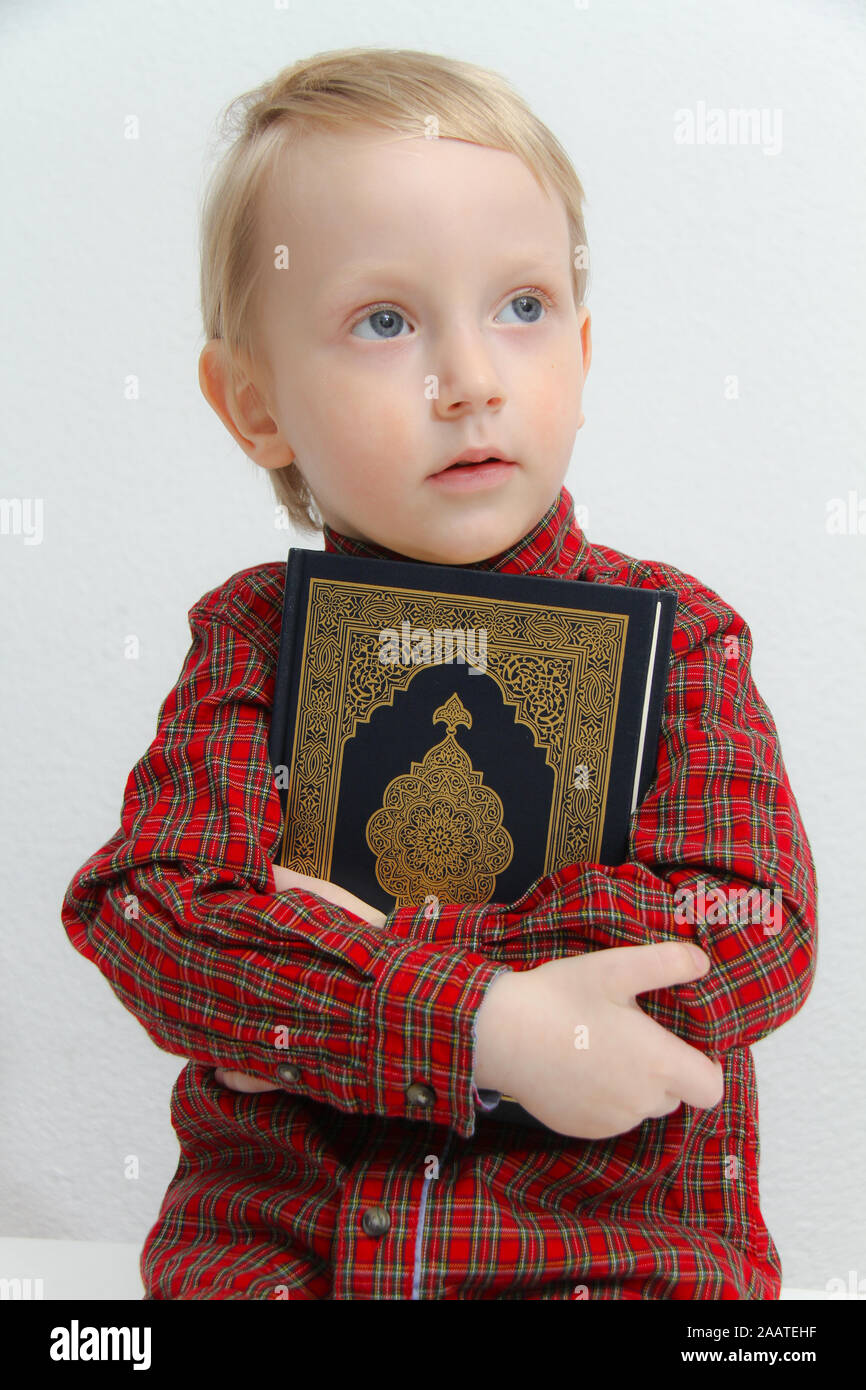 Little muslim European boy with islamic holy book Quran or Kuran Stock ...