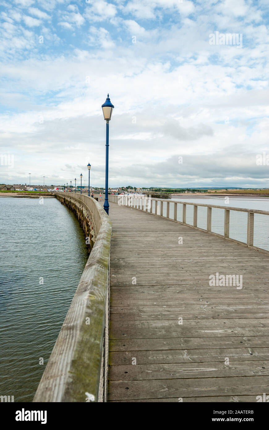 View towards the shore along an old English wooden jetty lined with ...