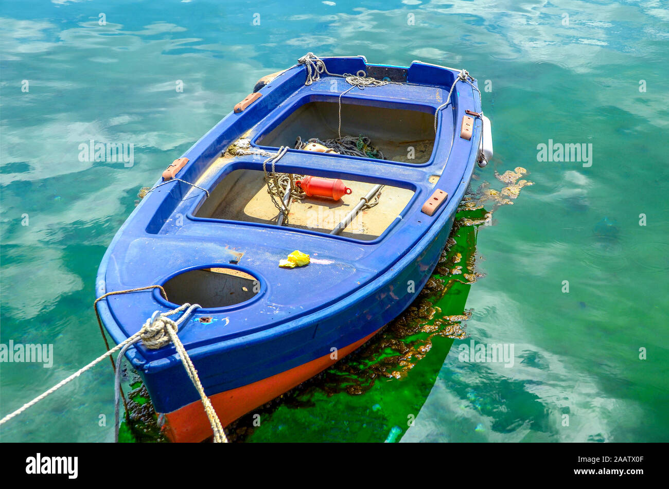 small traditional fishing boat floating on green waters Stock Photo - Alamy
