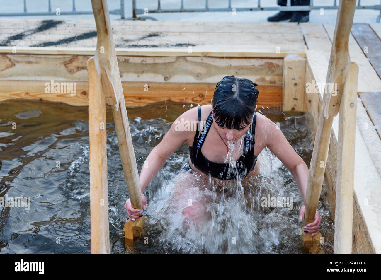 Woman Bathes Into Cold Water Of Ice Hole On Epiphany Day Traditional Ice Swimming In Orthodox