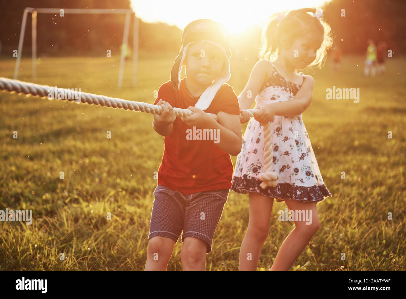 Boy and girl pulling a rope and playing tug of war at the park Stock ...