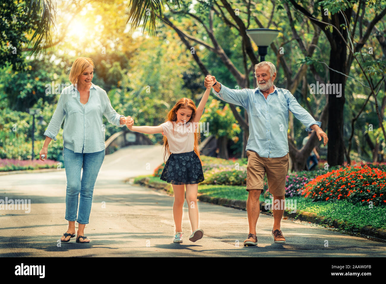 Happy healthy family walk together on path in the park in summer ...