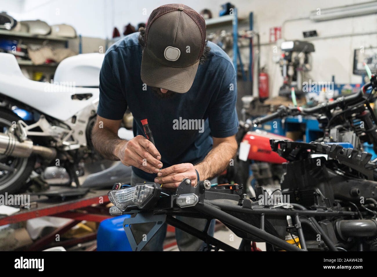 Mechanic in a repair garage repairing a motorcycle Stock Photo - Alamy