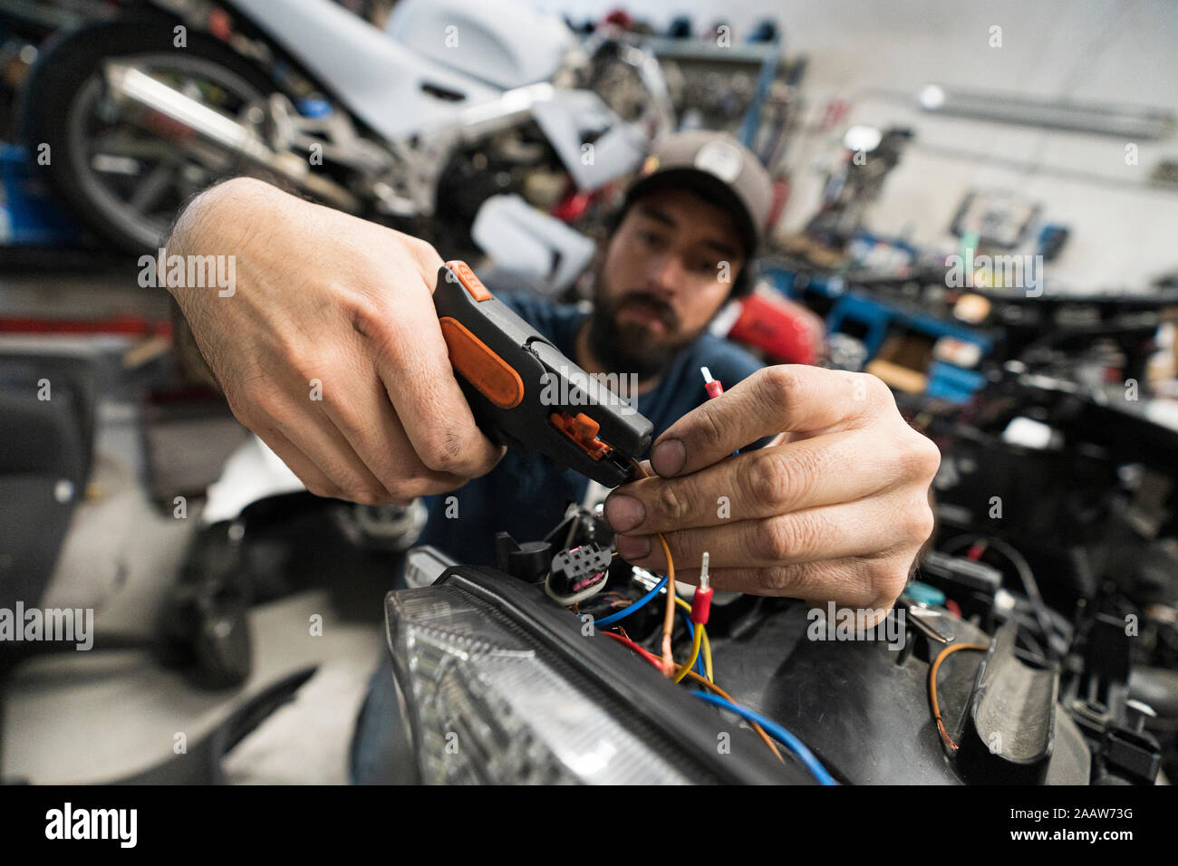 Mechanic in a repair garage repairing a motorcycle Stock Photo - Alamy