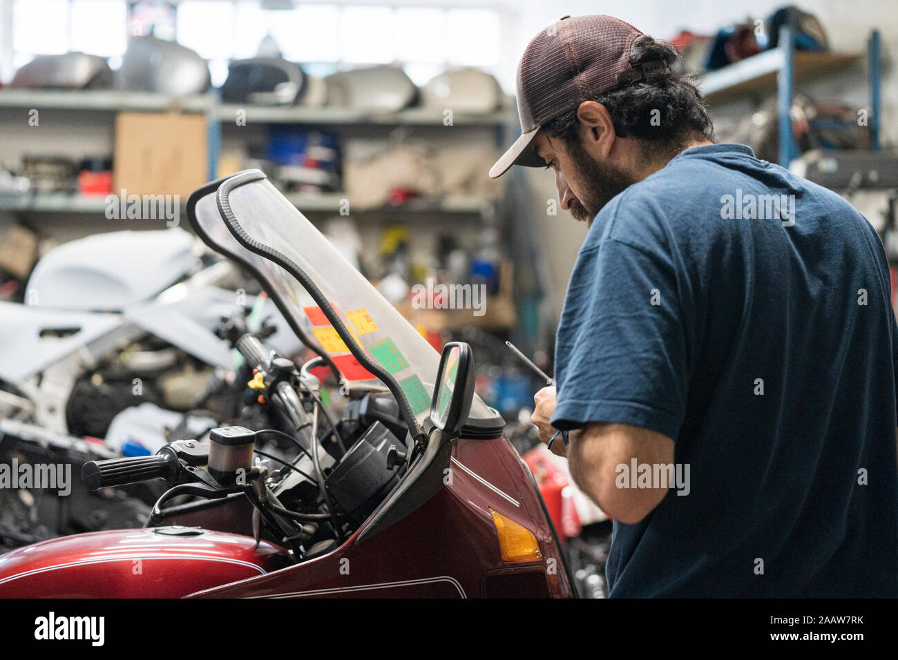 Mechanic in a repair garage repairing a motorcycle Stock Photo - Alamy