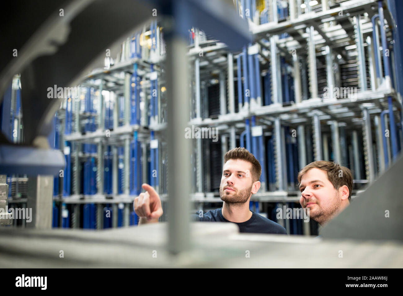 Worker with colleague in factory warehouse pointing his finger Stock ...
