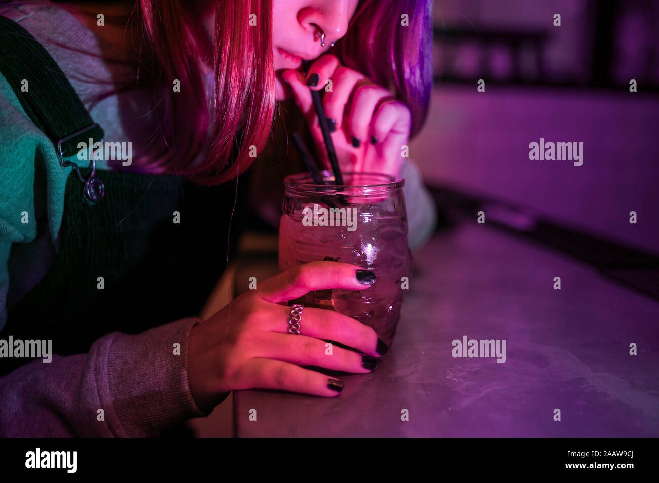 Young woman having a drink at night Stock Photo - Alamy