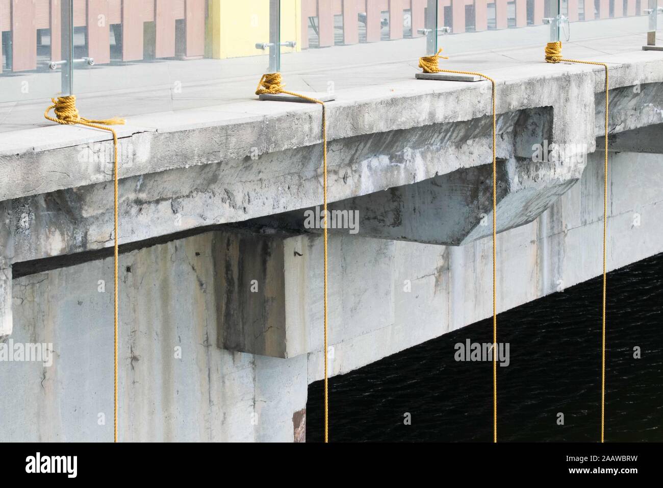 Four yellow rope tied to a concrete pavement hanging Stock Photo - Alamy