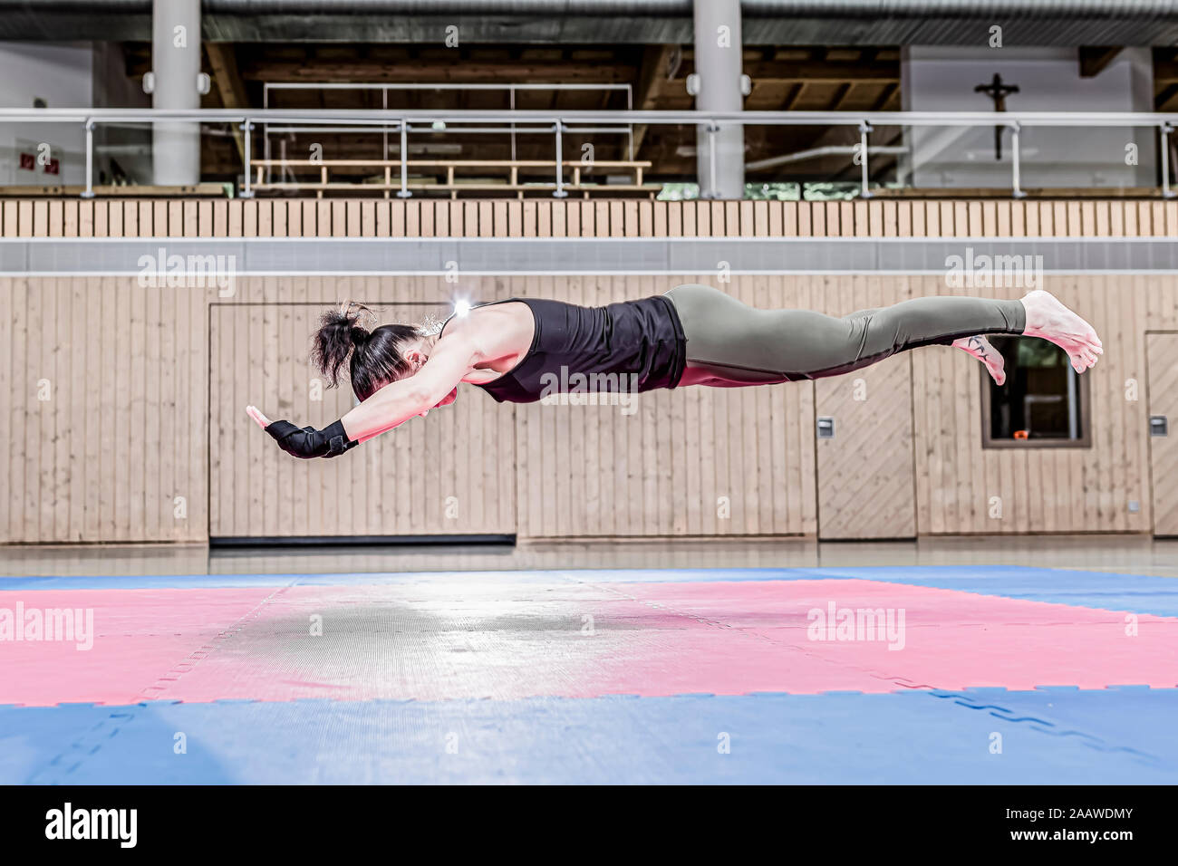 Woman exercising in sports hall floating mid-air Stock Photo - Alamy