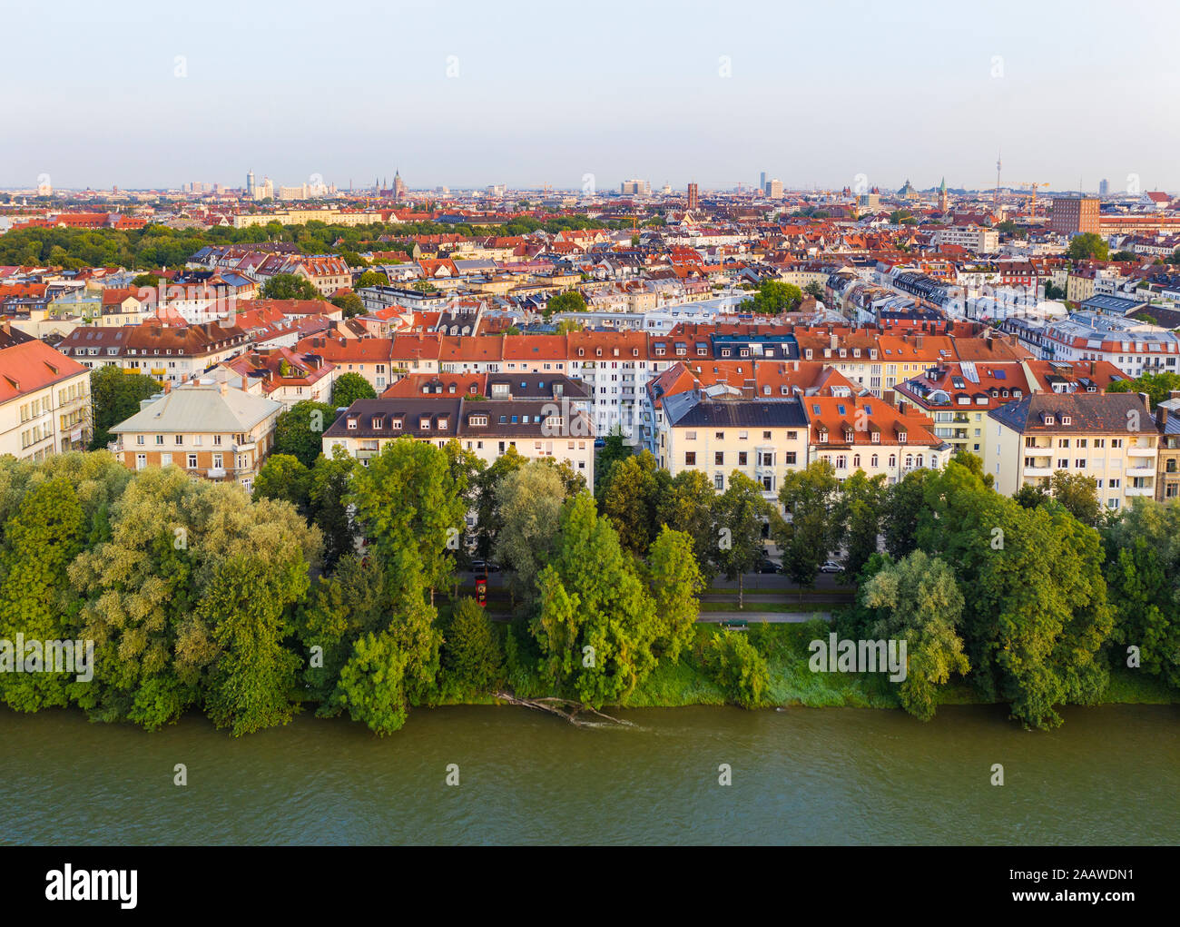 Germany, Upper Bavaria, Munich, Trees along Isar river with city ...