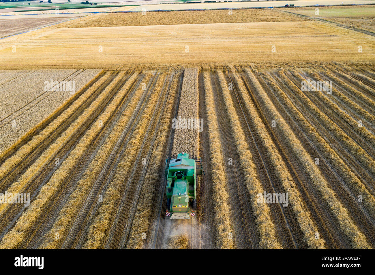 Aerial view of combine harvester on agricultural field during sunset ...
