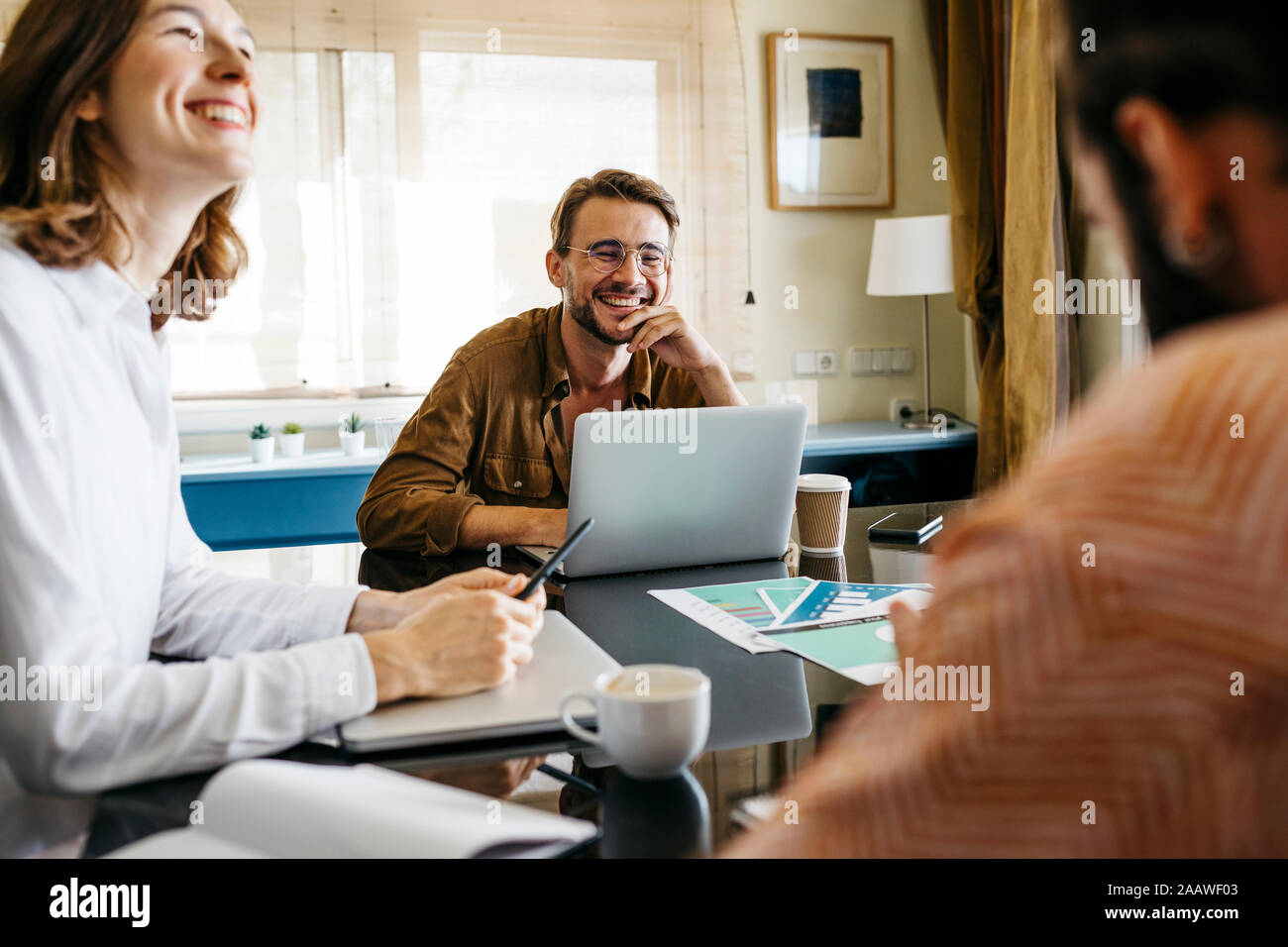 Happy friends working together on table at home Stock Photo - Alamy