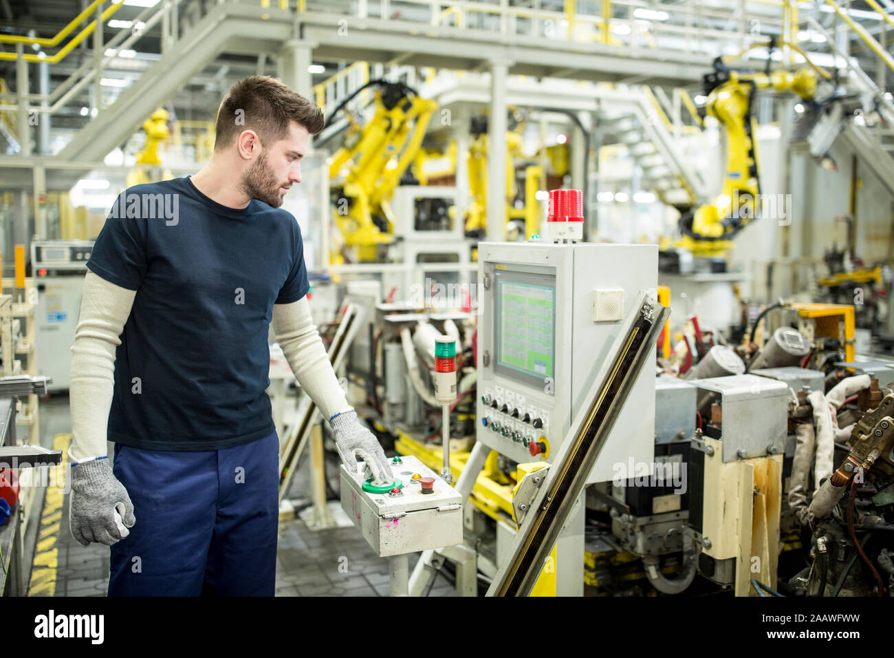 Man working in a modern factory operating a machine Stock Photo - Alamy