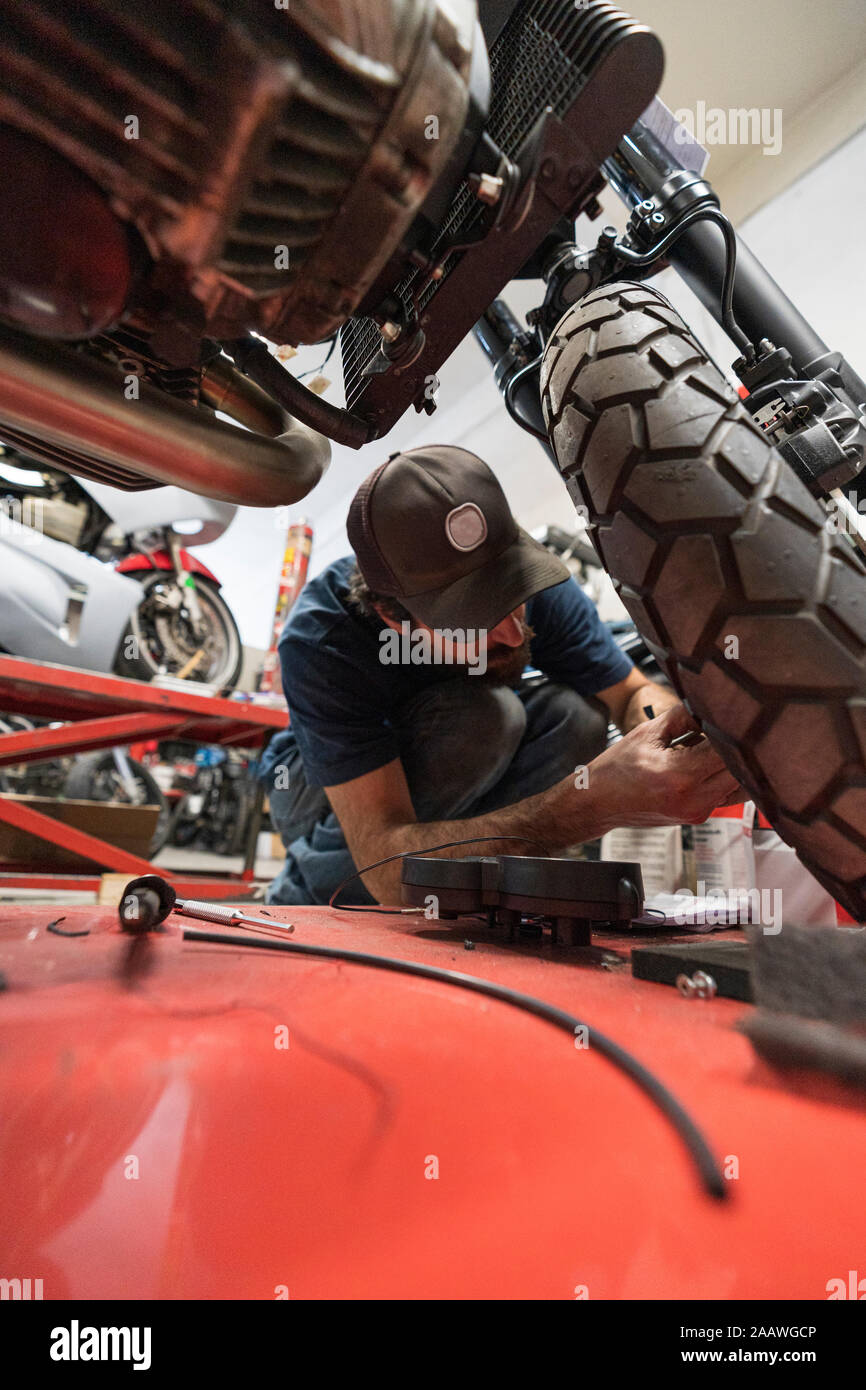 Mechanic in a repair garage repairing a motorcycle Stock Photo - Alamy